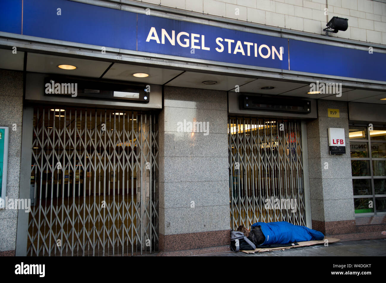 London. Islington. Angel Station. Homeless man sleeping on the pavement ...