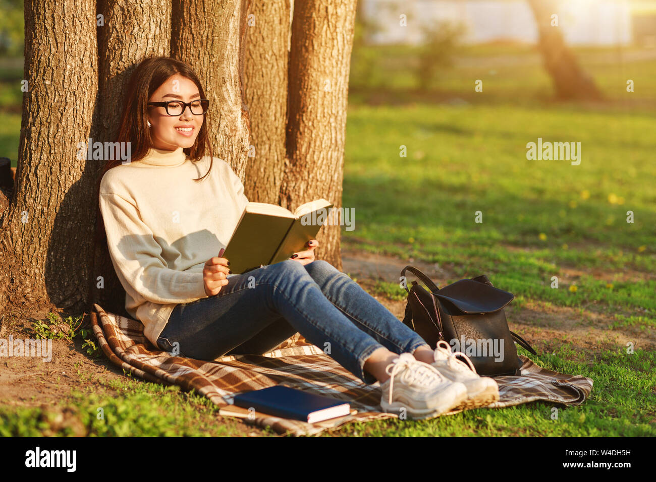 Girl Reading A Book Under A Tree
