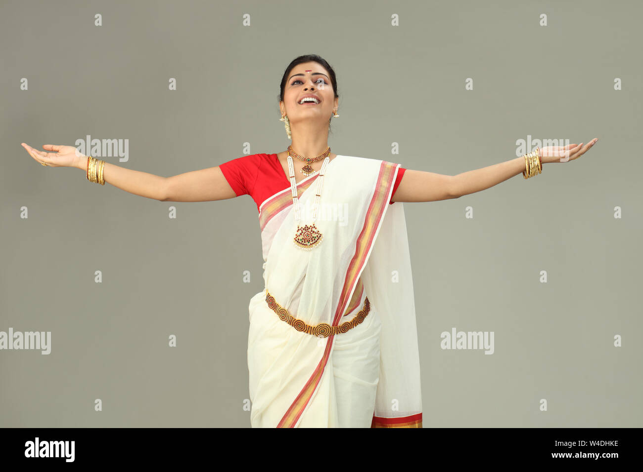 South Indian woman standing with her arm outstretched Stock Photo - Alamy
