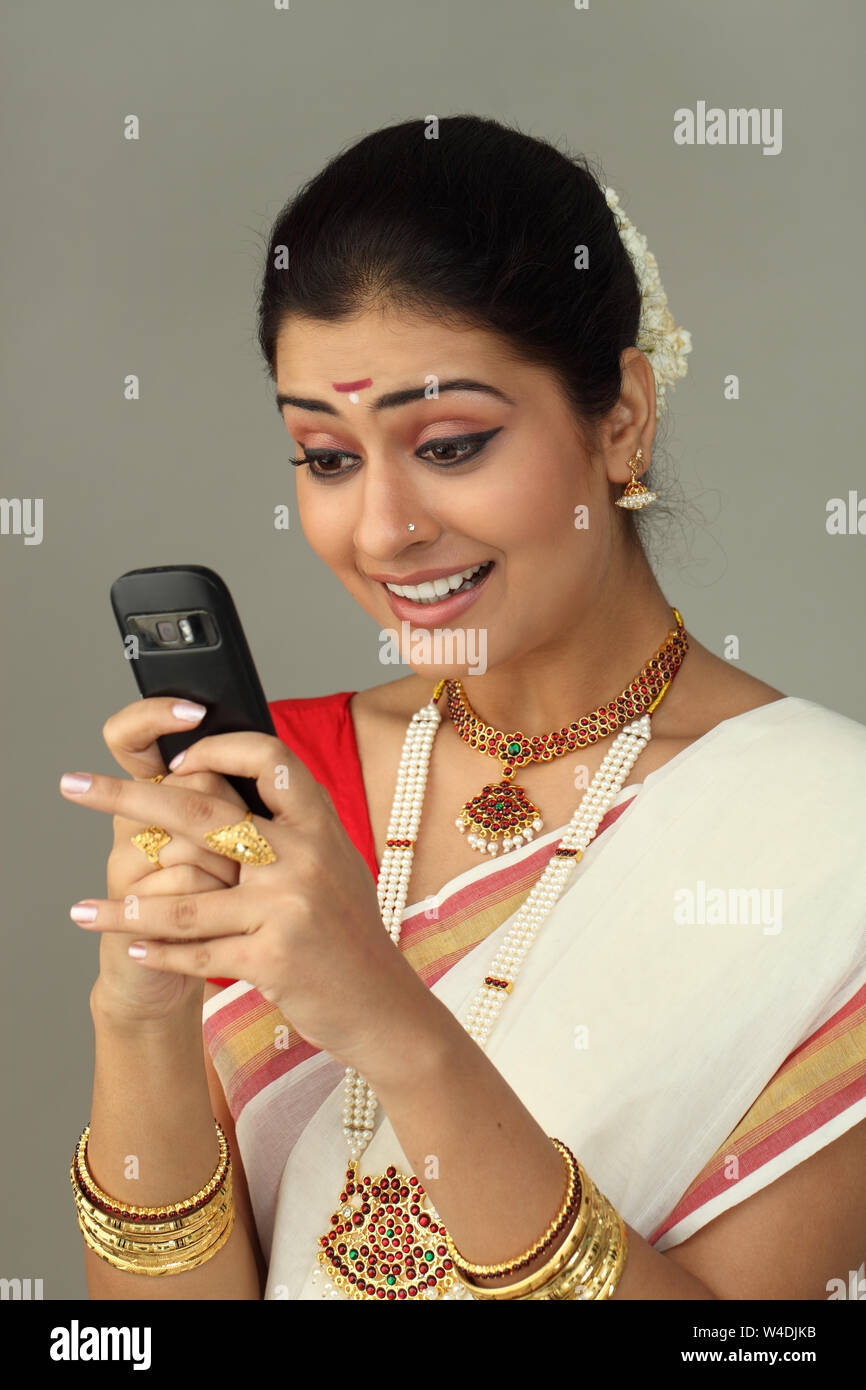 South Indian woman text messaging and smiling Stock Photo - Alamy