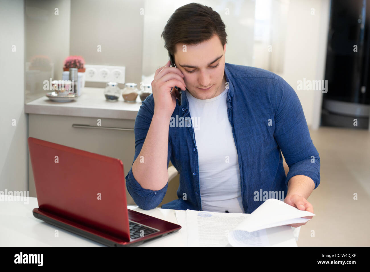 young handsome man working in his laptop from home freelancing talking ...