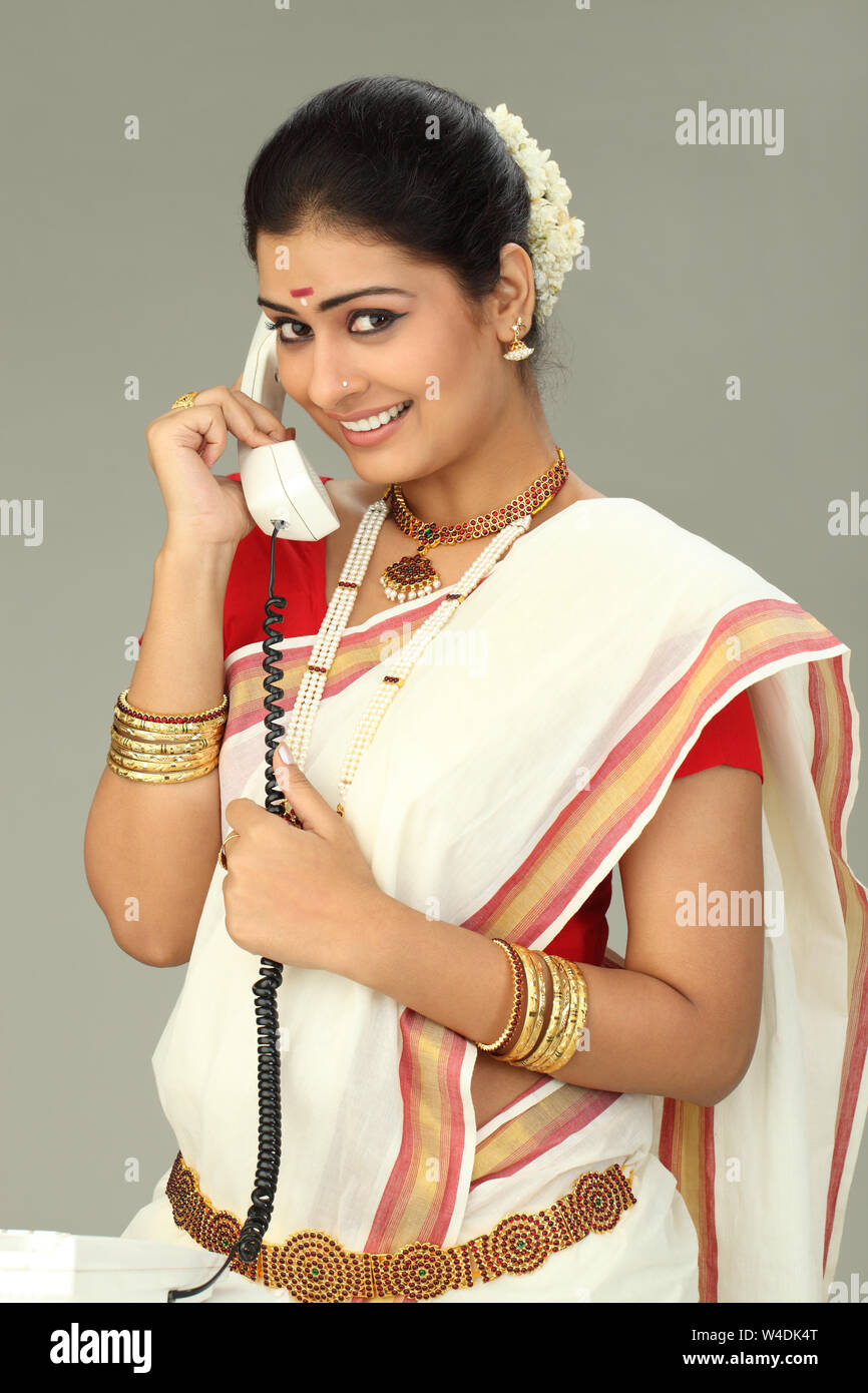 South Indian woman talking on landline phone and smiling Stock Photo ...
