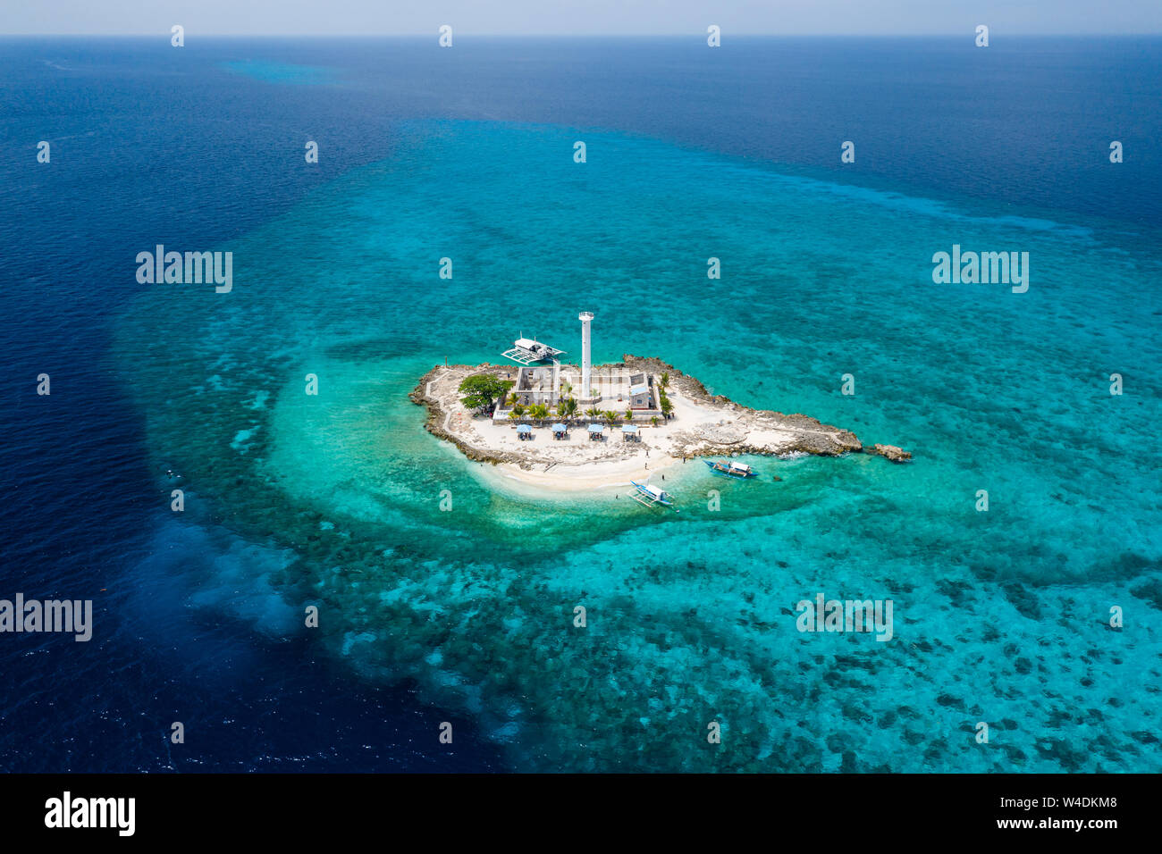 Aerial view of a tiny tropical island with a lighthouse surrounded by a ...