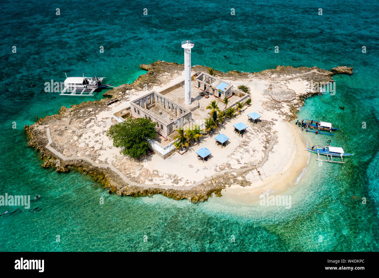 Aerial view of a tiny tropical island with a lighthouse surrounded by a ...