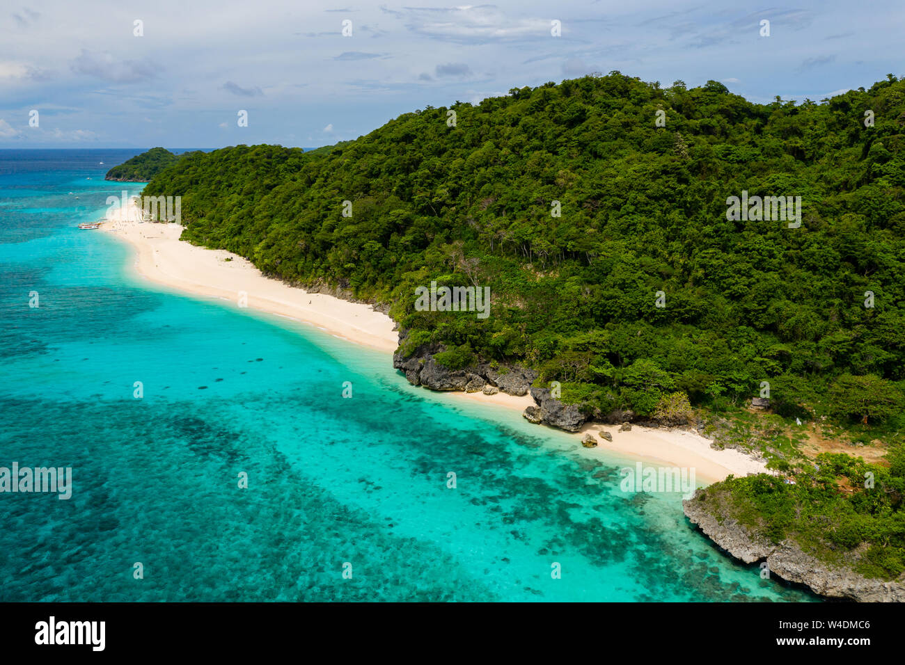 Aerial view of a beautiful sandy beach surrounded by tropical foliage ...