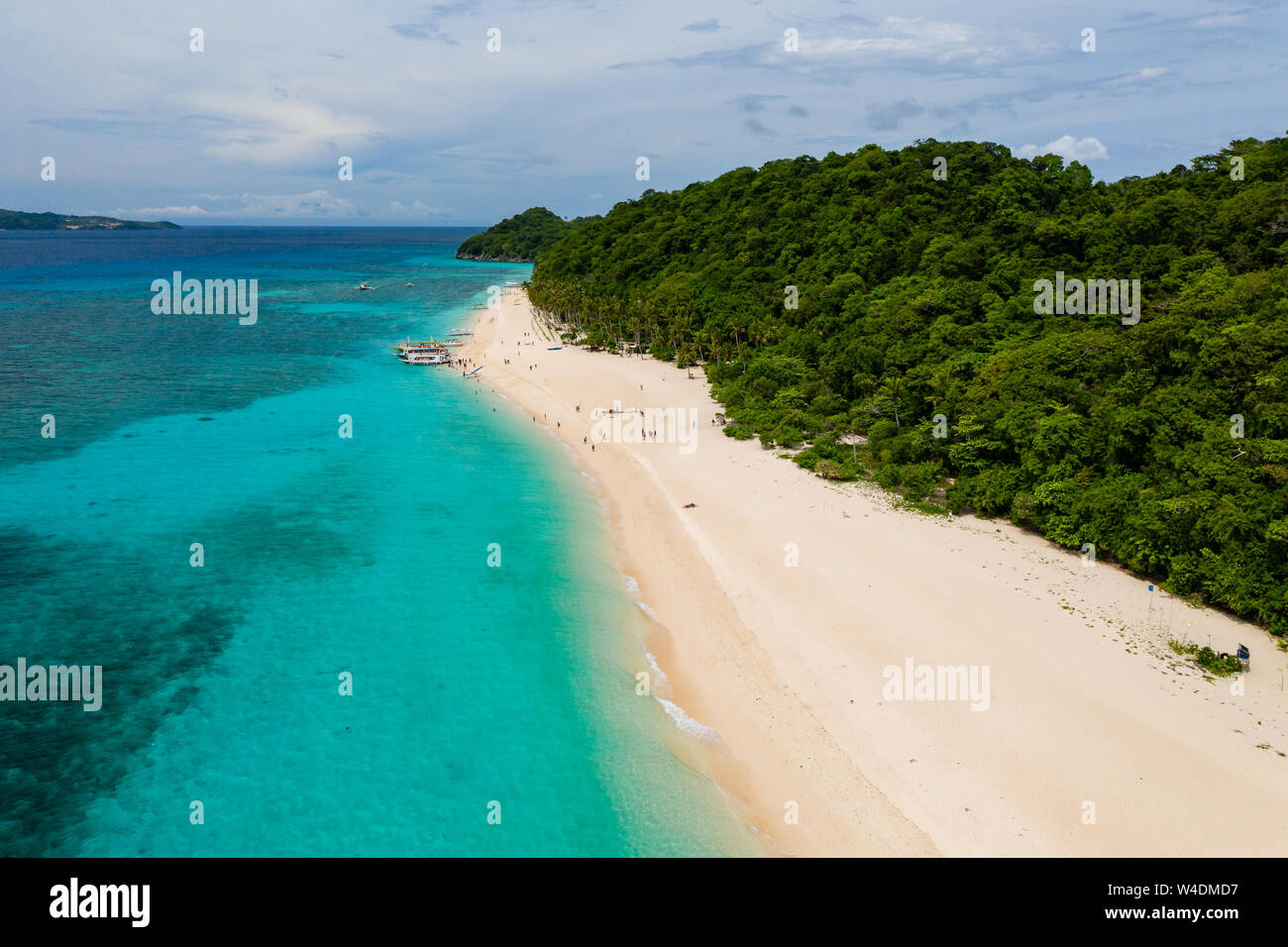 Aerial view of a beautiful sandy beach surrounded by tropical foliage ...