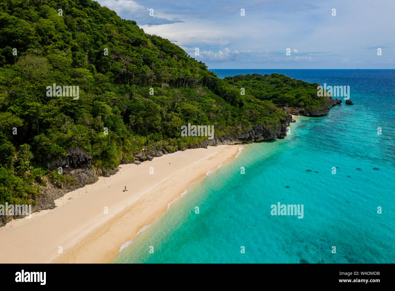 Aerial view of a beautiful sandy beach surrounded by tropical foliage ...