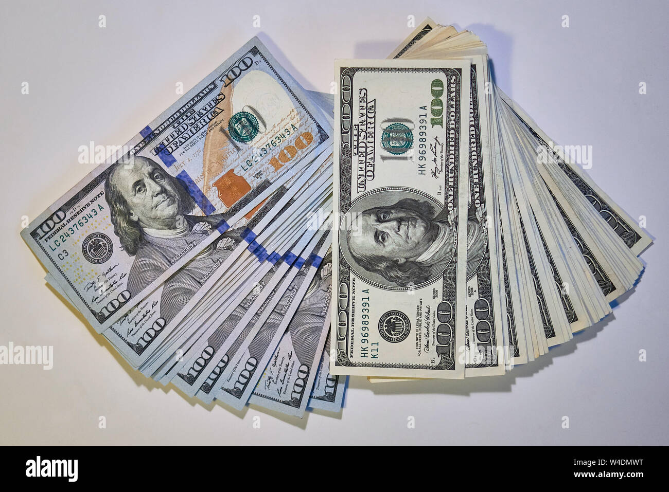 Stack of old and new notes of 100 US dollars bills on a white ...