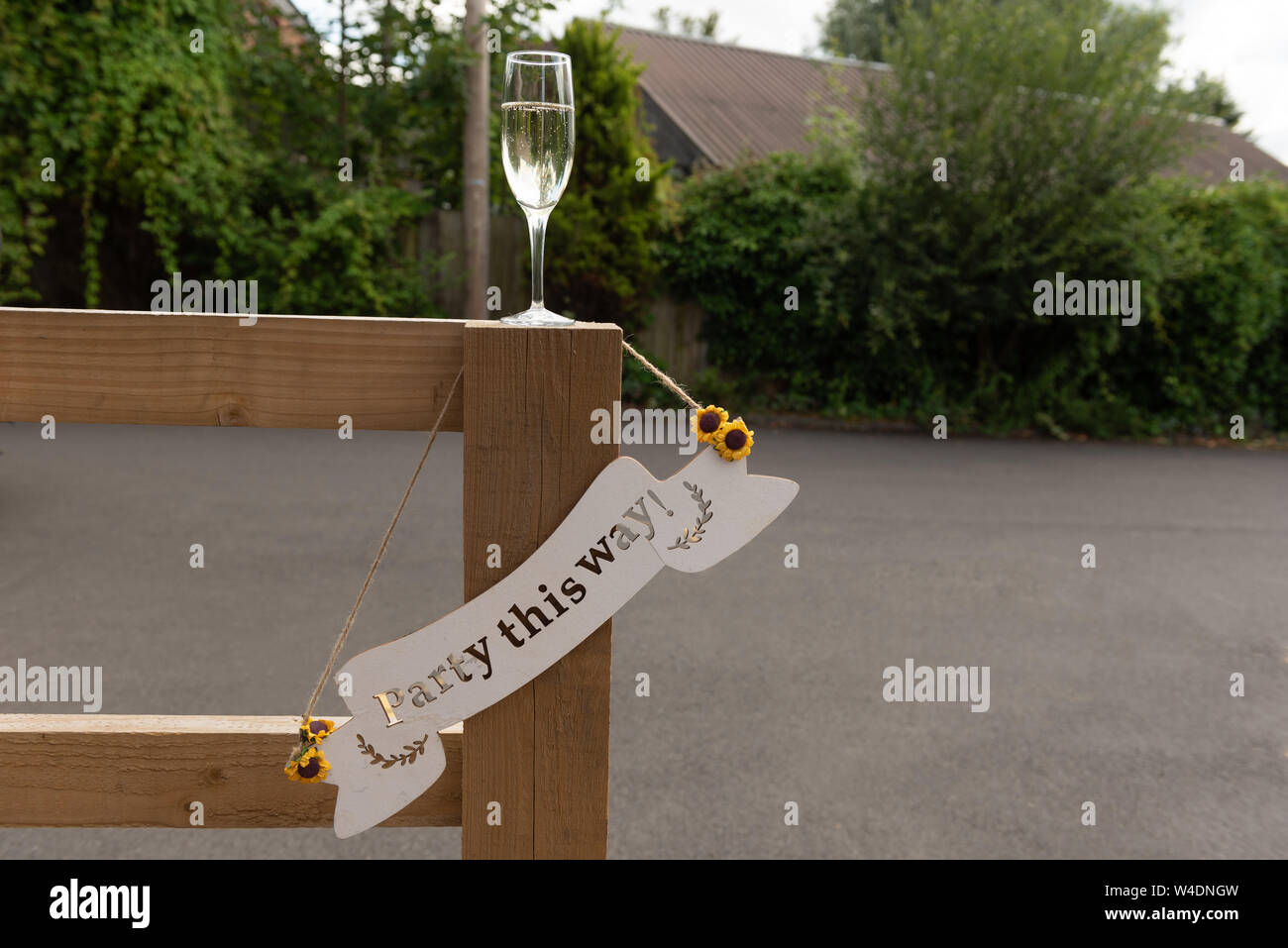 party this way sign with champagne glass on fence Stock Photo - Alamy