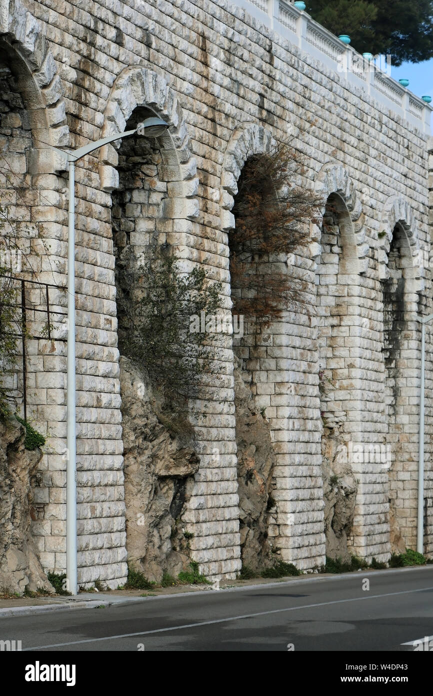 Tall old stone wall next to a road Stock Photo - Alamy