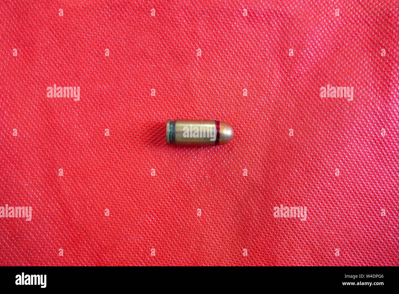 Gun cartridge on red background. Bullet moves horizontally. Closeup ...