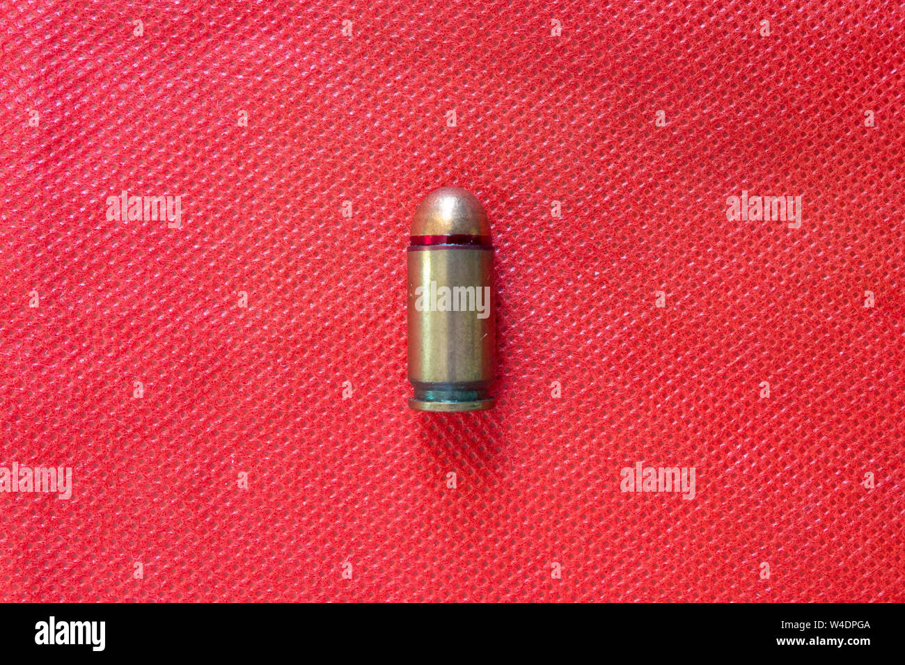 Gun cartridge on red background. Bullet moves vertically. Closeup ...