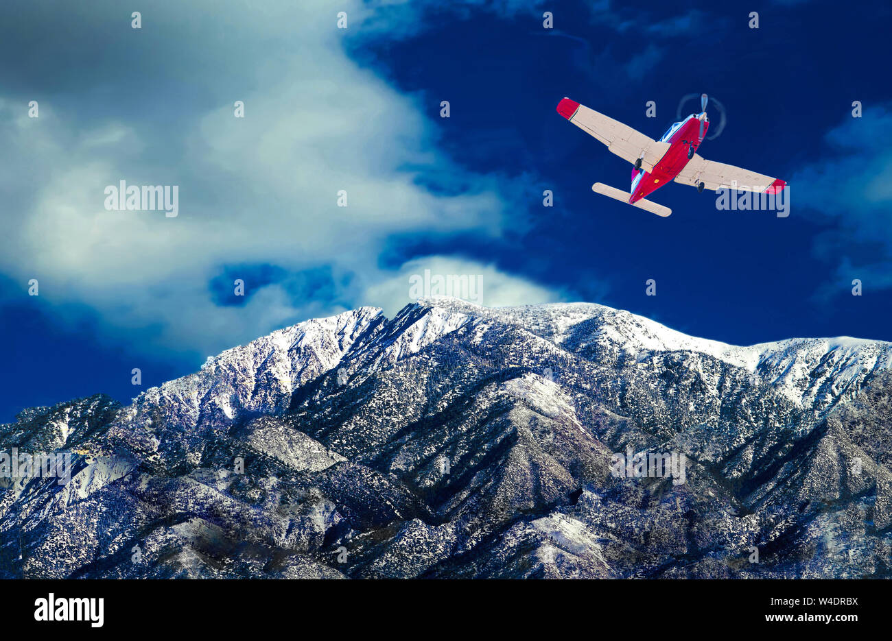 Airplane in flight over snow capped mountain peaks Stock Photo - Alamy
