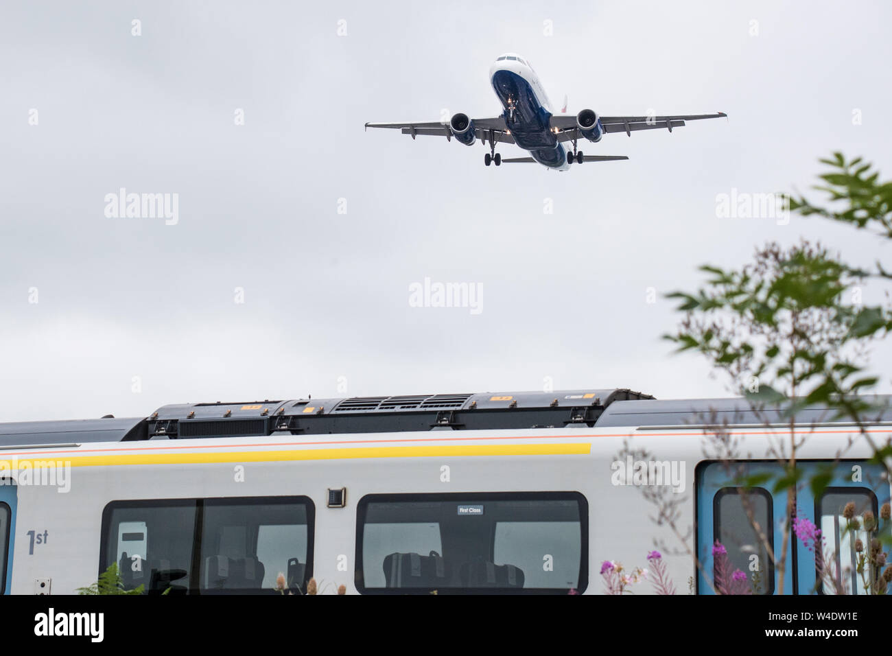 An aeroplane over Thameslink train at Gatwick airport Stock Photo - Alamy