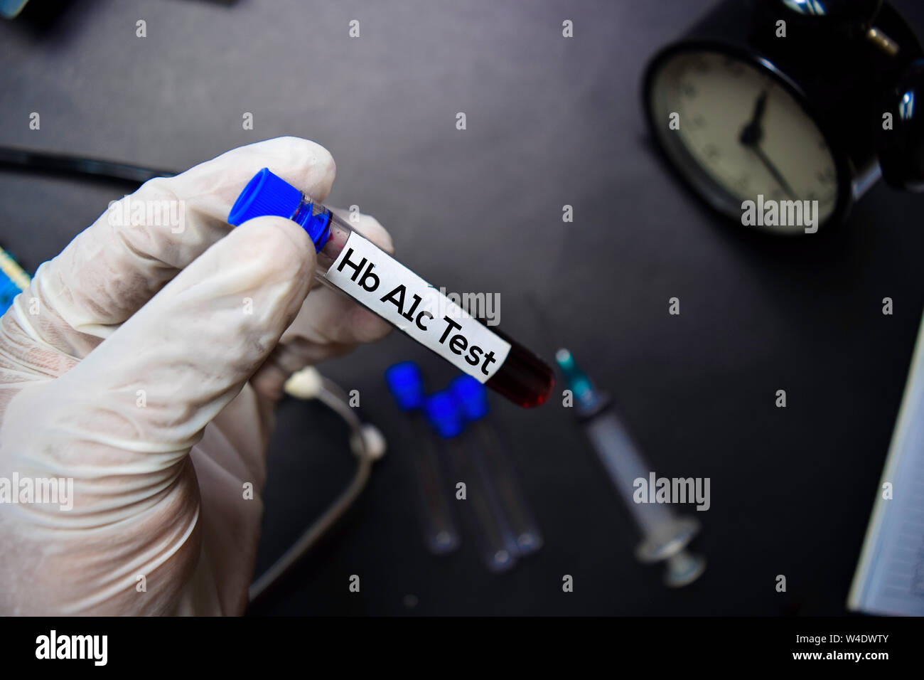 Hb A1c Test text with blood sample. Top view isolated on black ...