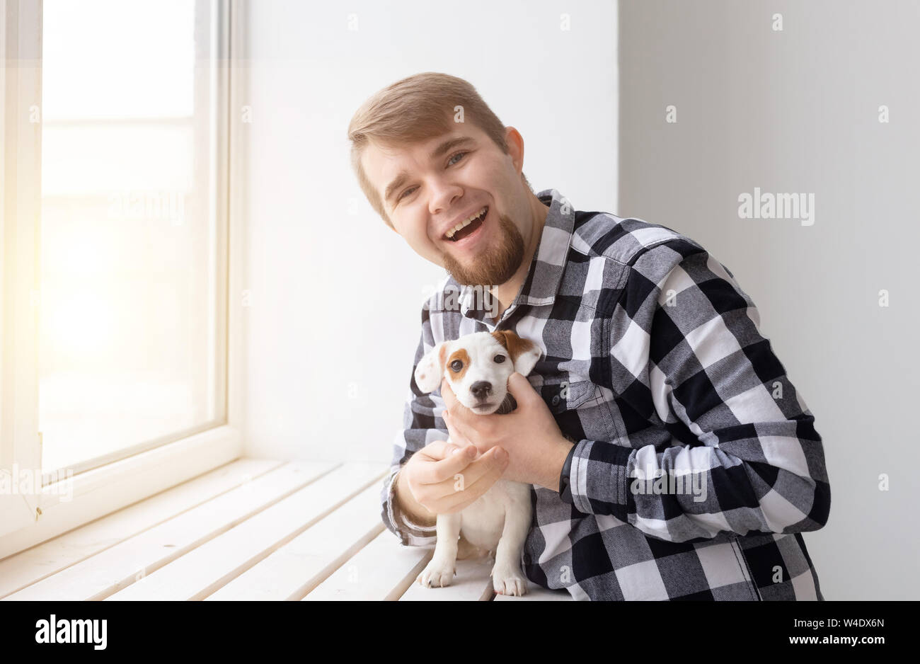People and pet concept - Happy man holding a dog Jack Russell Terrier ...