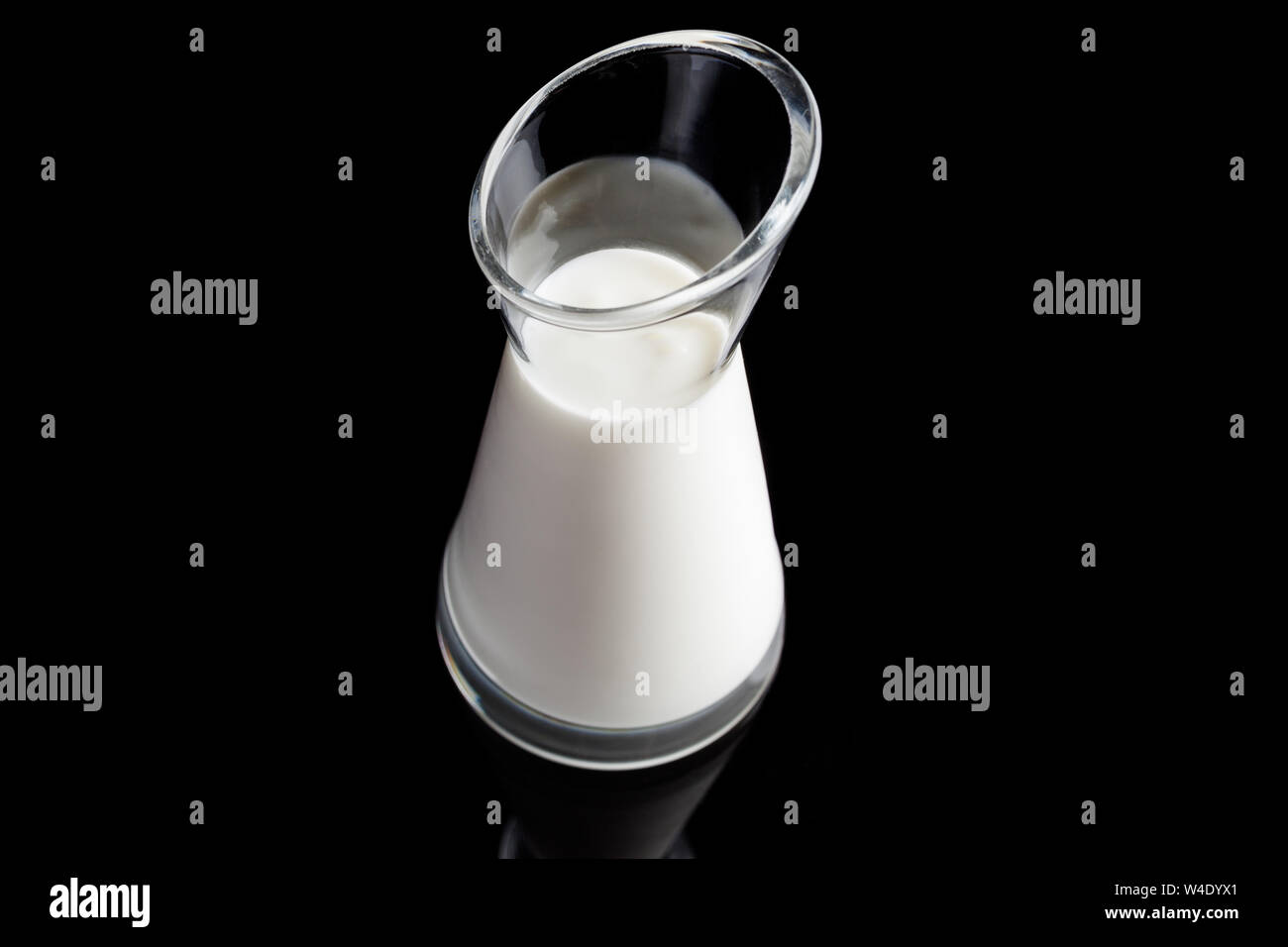 Glass pitcher with white yogurt on black background from above Stock ...
