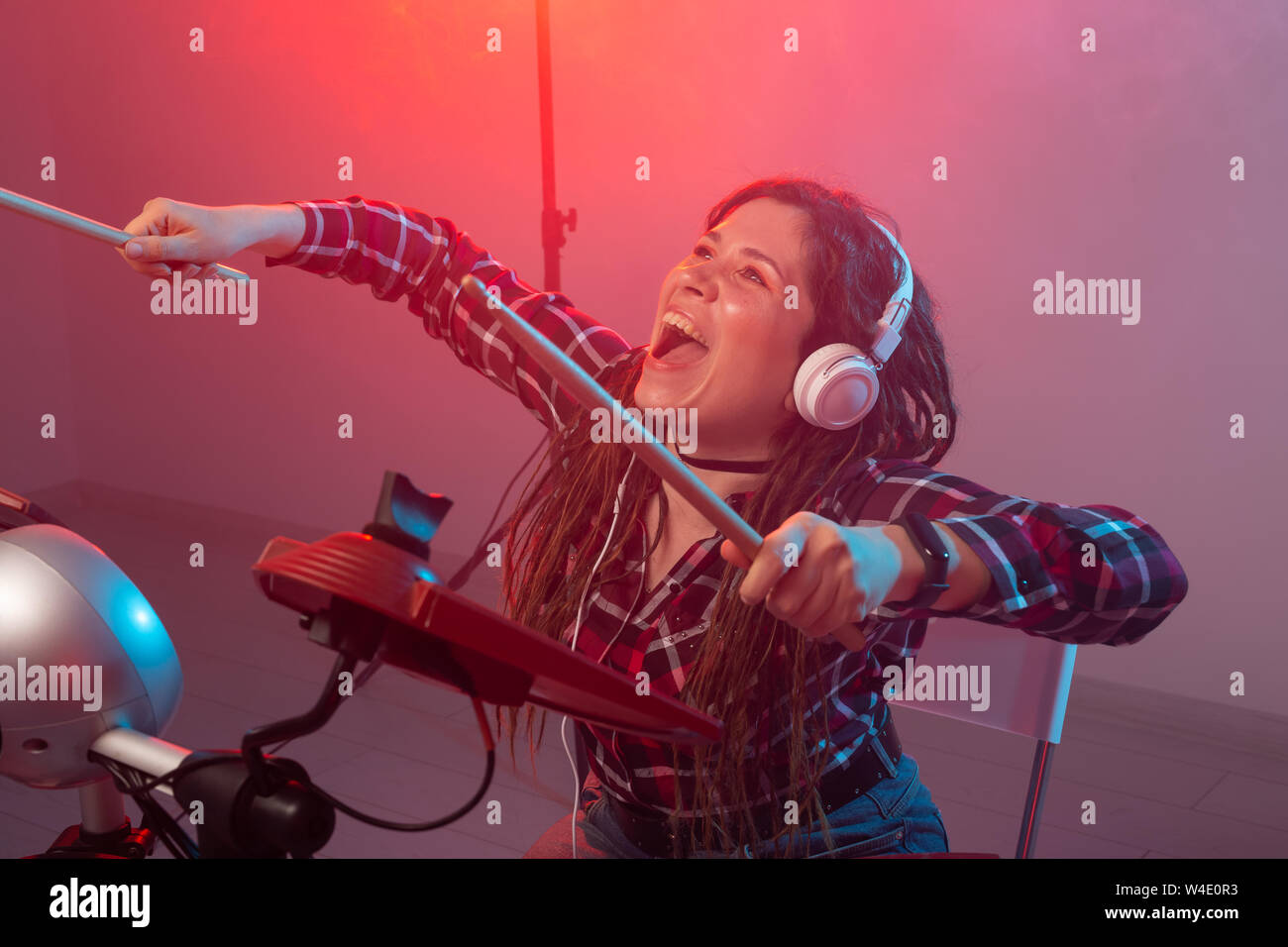 Electronic drum set, music and hobby concept - young woman drummer ...