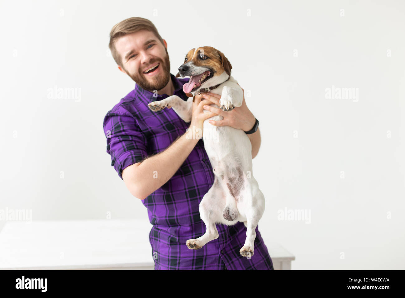 Pet's owner concept - Happy man holding a dog Jack Russell Terrier over ...