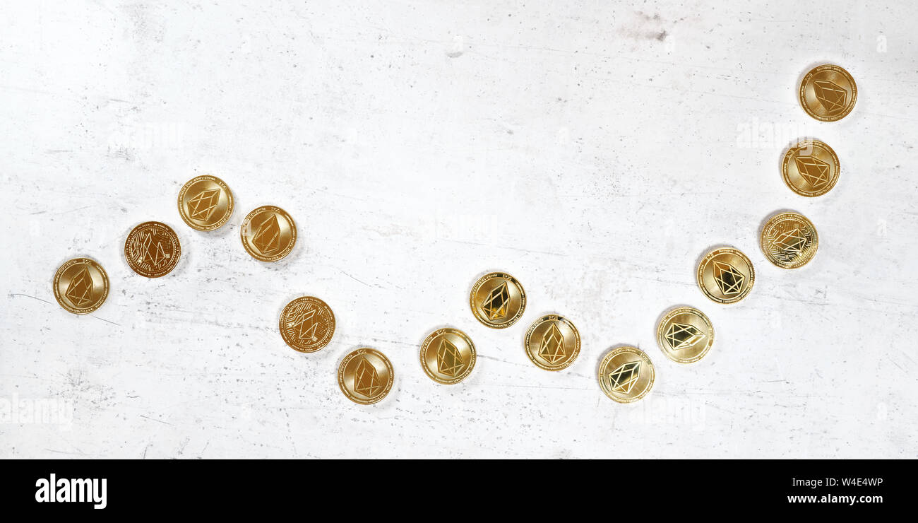 Top down view, white stone board desk with golden EOS cryptocurrency ...