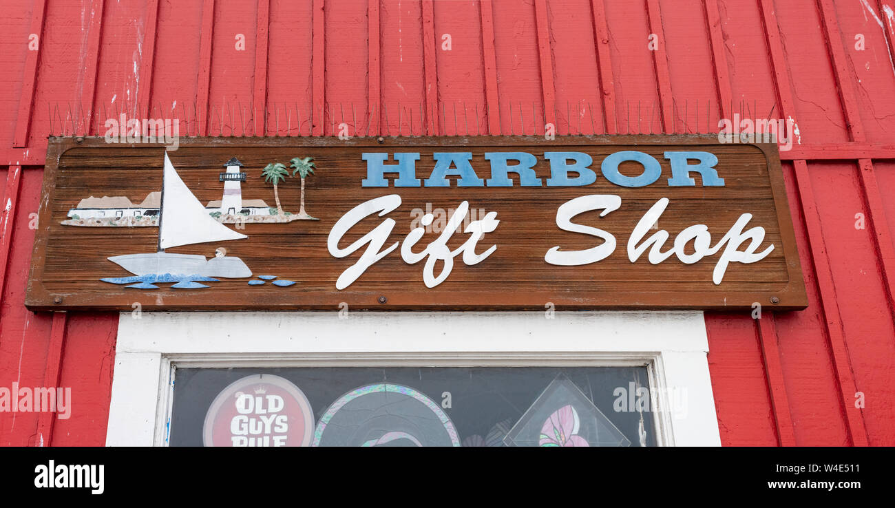 Wooden sign above store window, Sail boat, lighthouse. "Harbor Gift ...