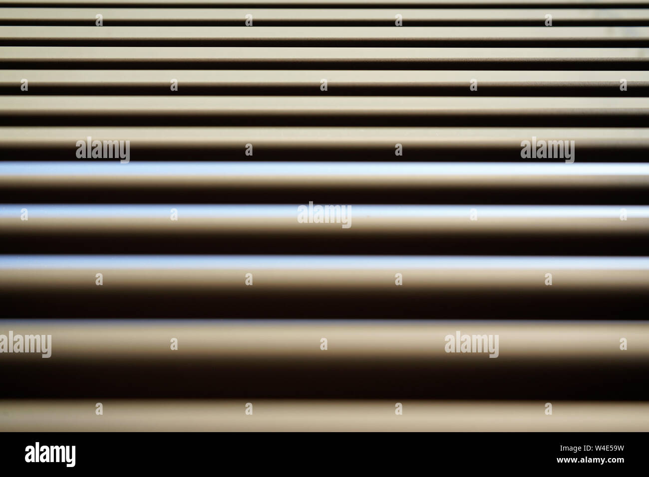 Detail on lines of metallic window blinds, some light reflects on, dust ...