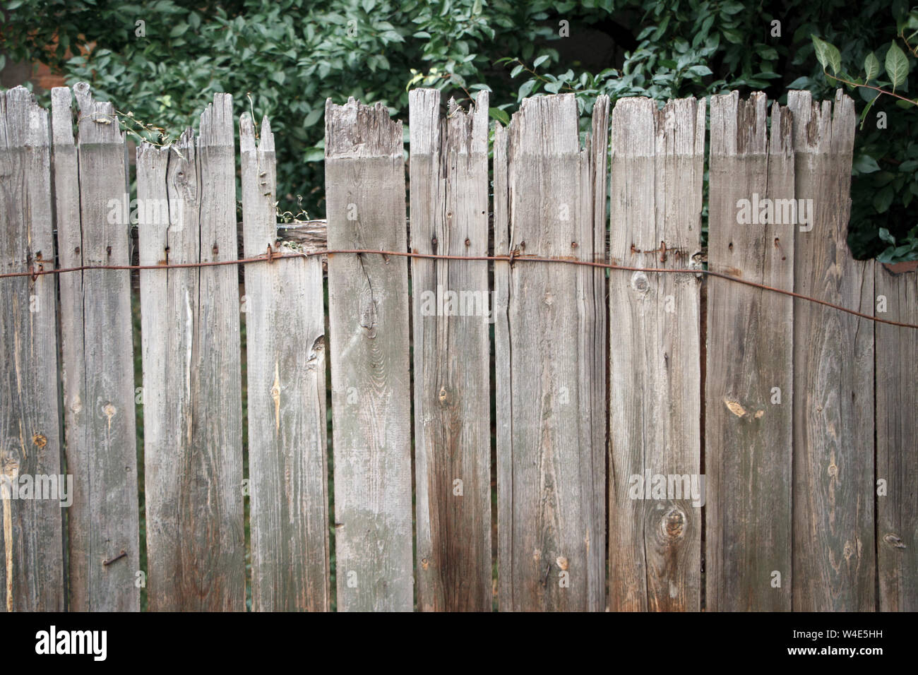 An old wooden fence with rusty bindings located in front of blurred ...