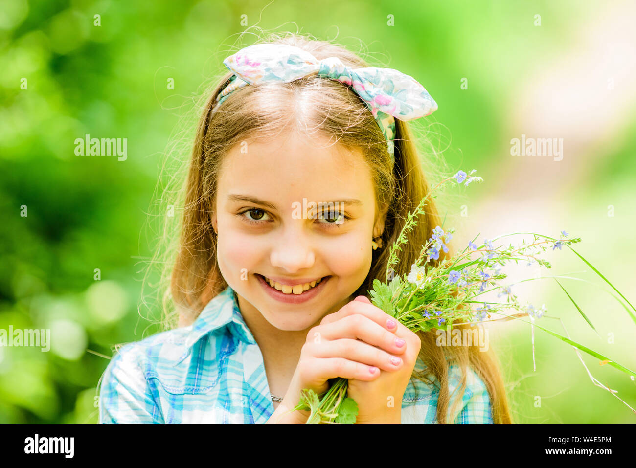 Collecting flowers in field. Kid hold flowers bouquet. Girl cute ...