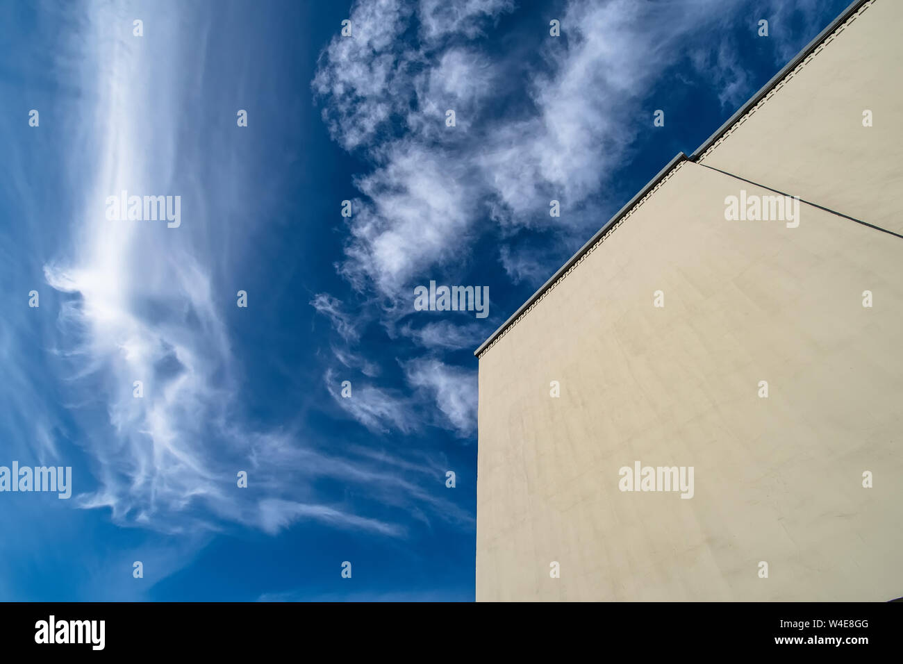 Large flat wall of a modern building without windows against a blue sky ...