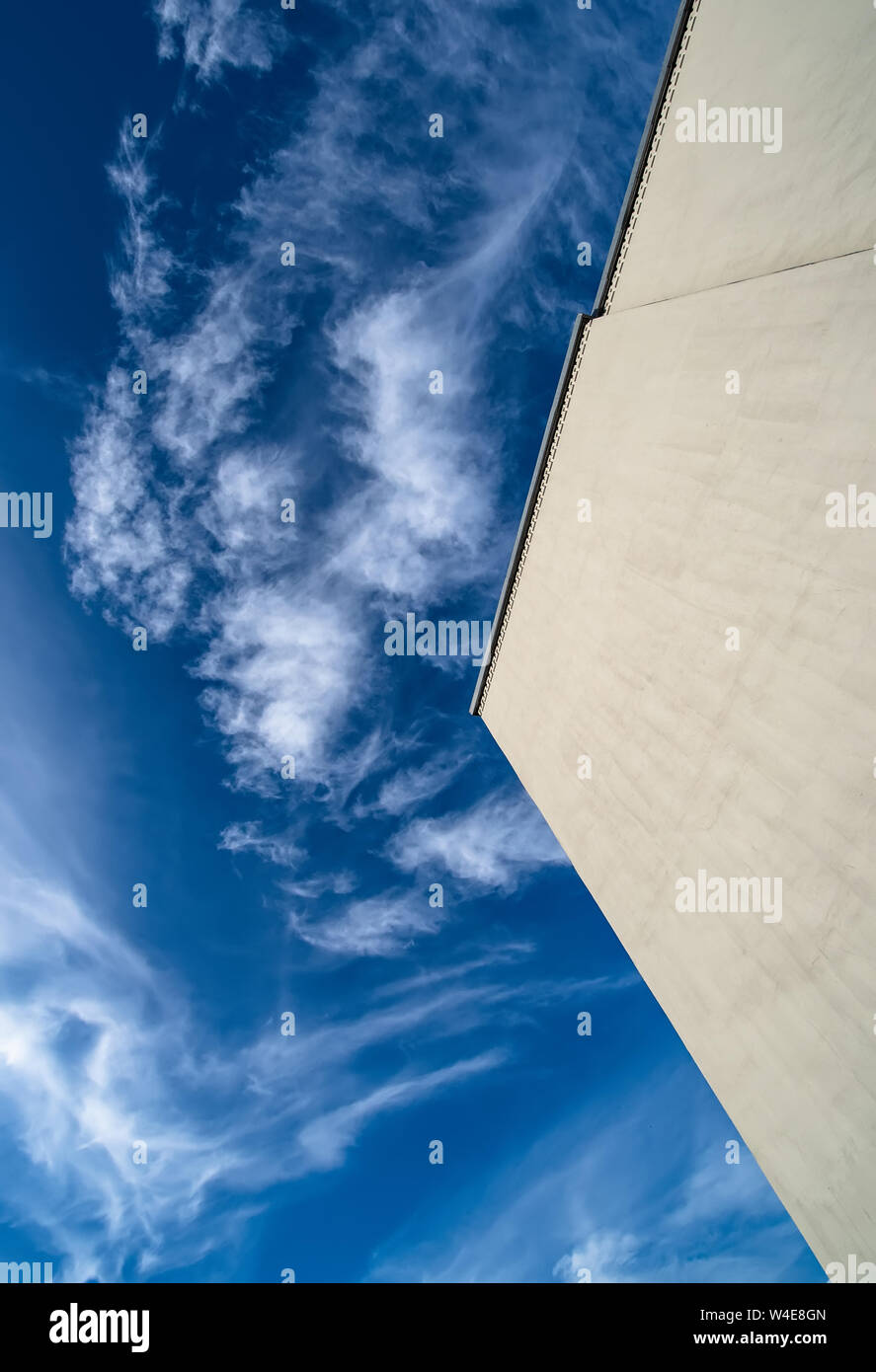 Large flat wall of a modern building without windows against a blue sky ...
