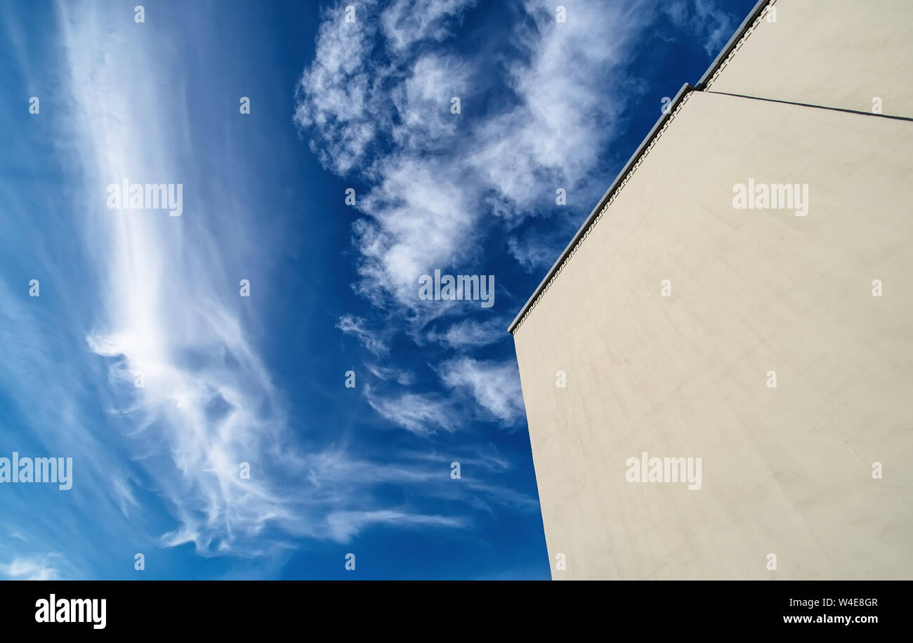 Large flat wall of a modern building without windows against a blue sky ...