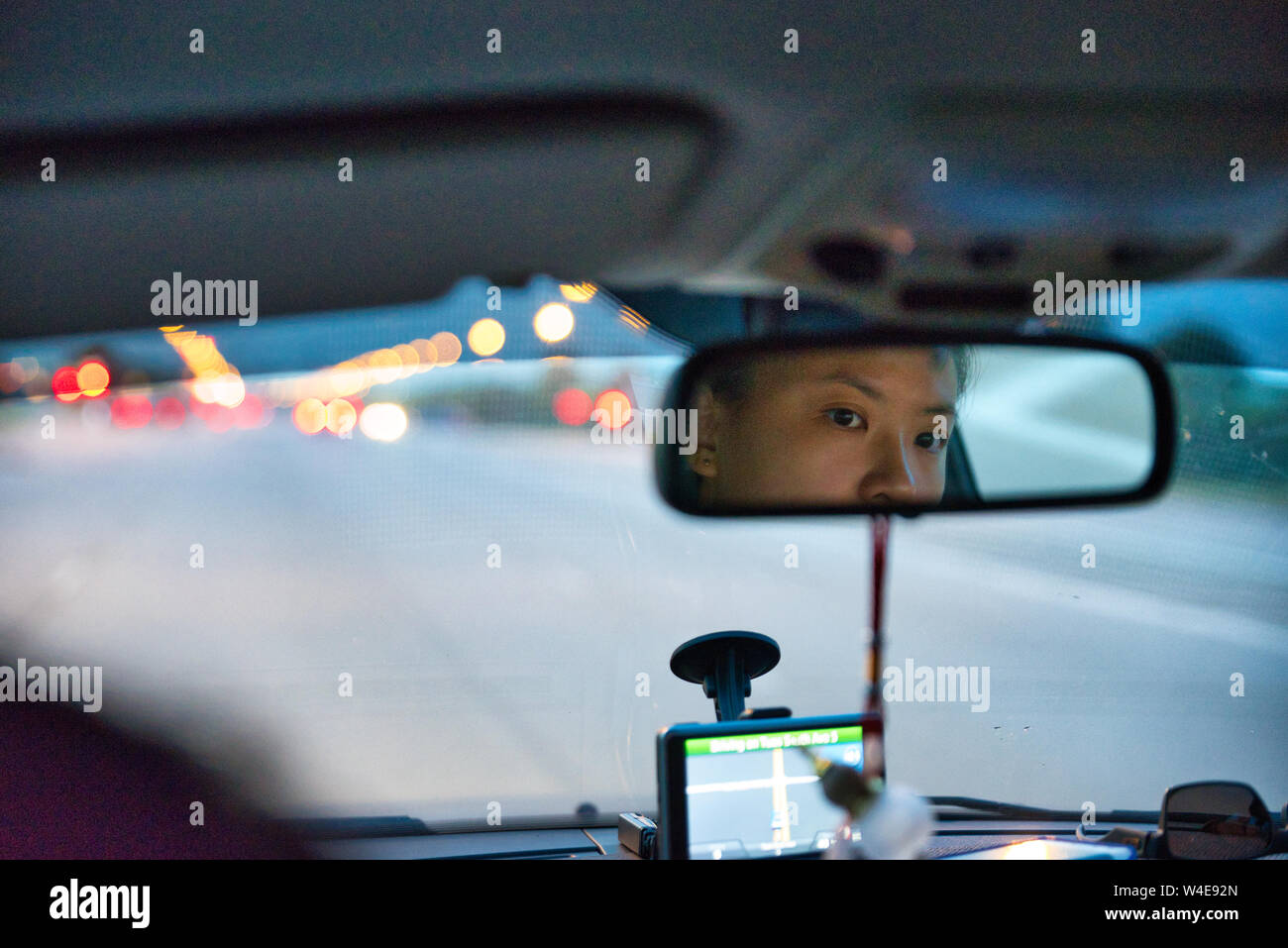 Driver looking at the back through the rear mirror Stock Photo - Alamy