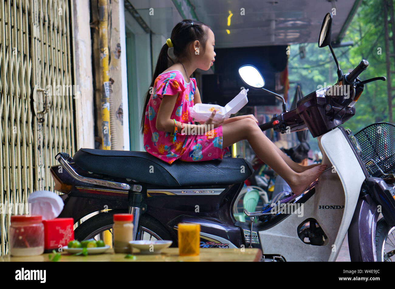 Girl sitting on motorcycle having lunch Stock Photo - Alamy