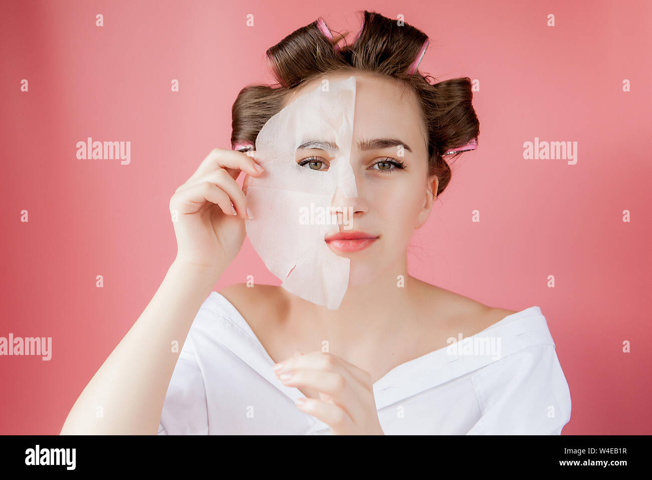 Beautiful young girl with a mask and curlers touching her face Stock ...