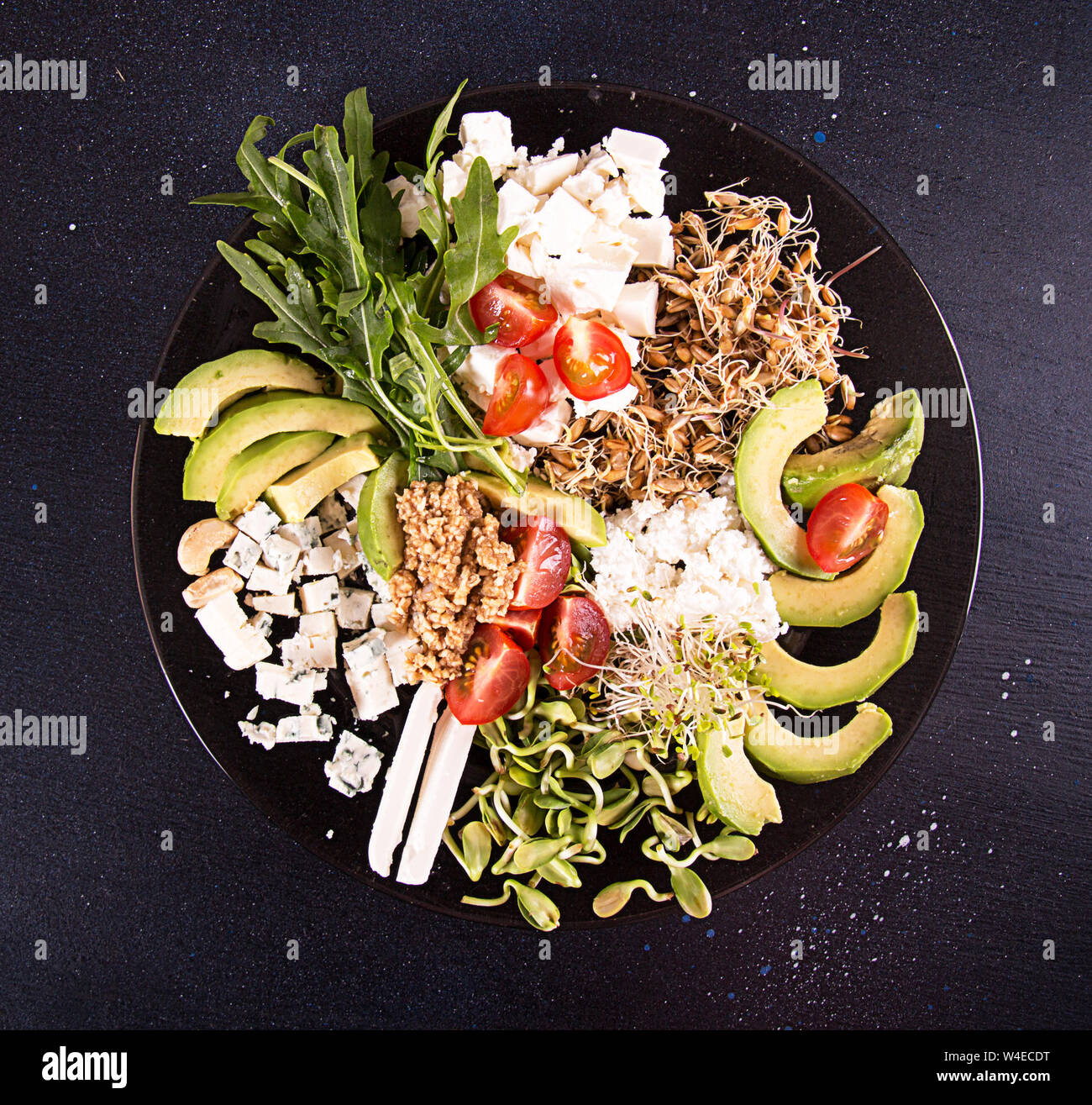 Healthy vegetarian salad of avocado, cherry tomato, sprouts, arugula ...