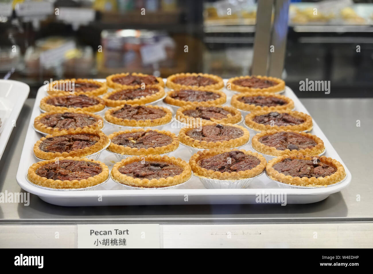 A tray of freshly baked Pecan tarts in a display window of a bakery ...