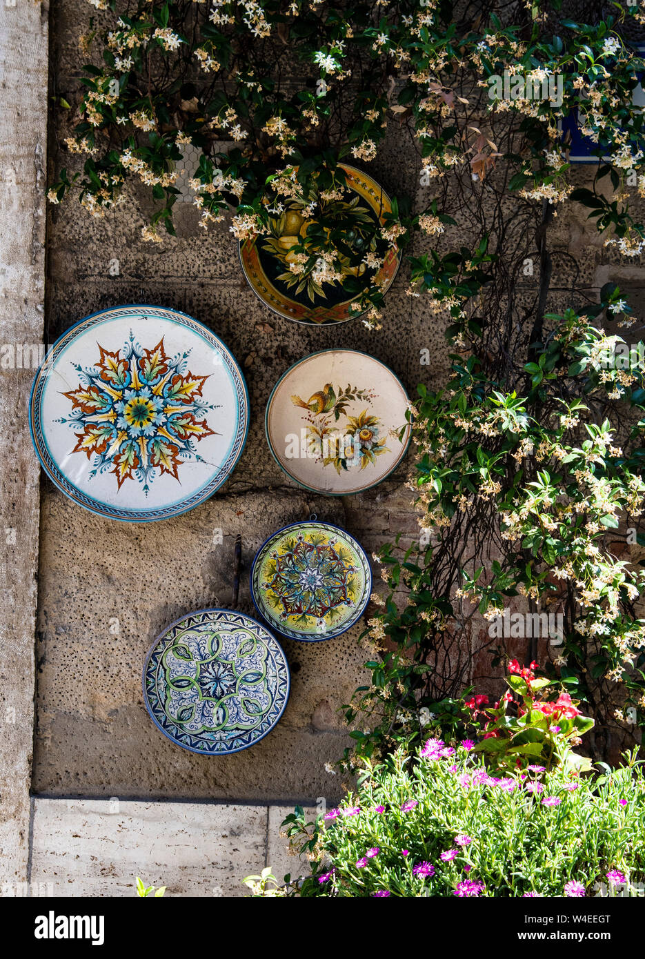 Hand painted and hand made Italian ceramic plates outside a home lined ...