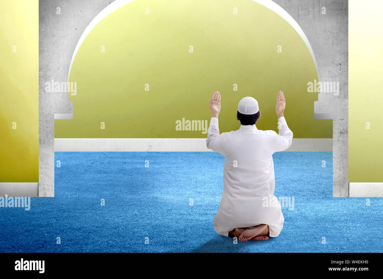 Rear View of Asian Muslim man sitting in pray position while raised ...