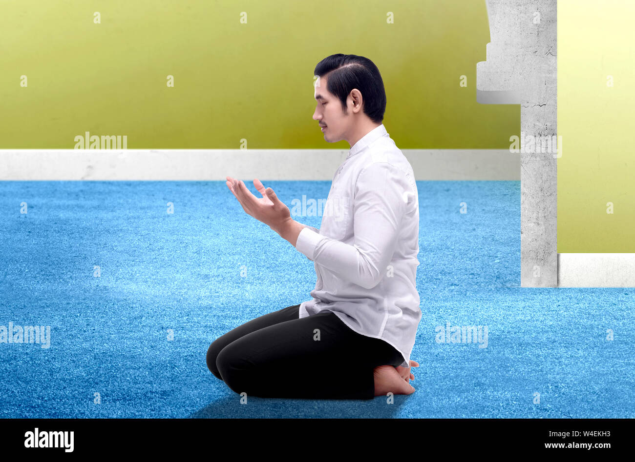 Asian Muslim man sitting while raised hands and praying inside the ...