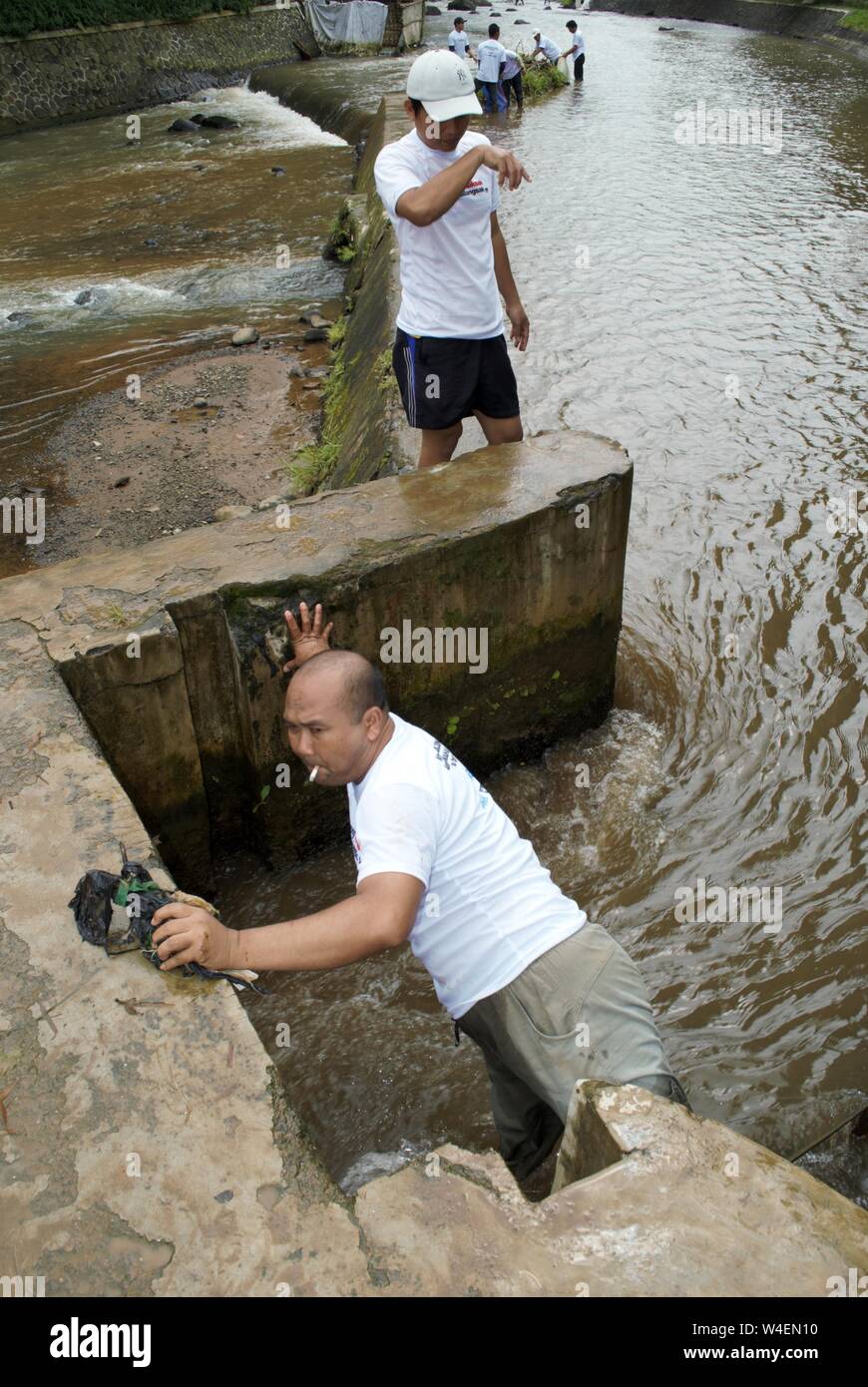 A man pick up trash in small dam in a river Stock Photo - Alamy