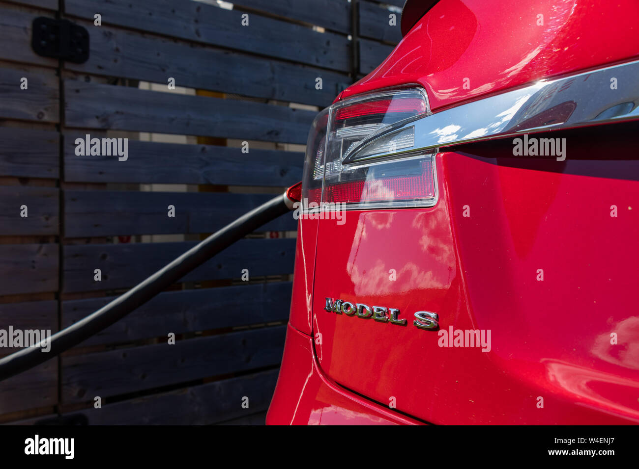 Tesla Model S plugged-in, charging seen at the rear with chrome Model S ...