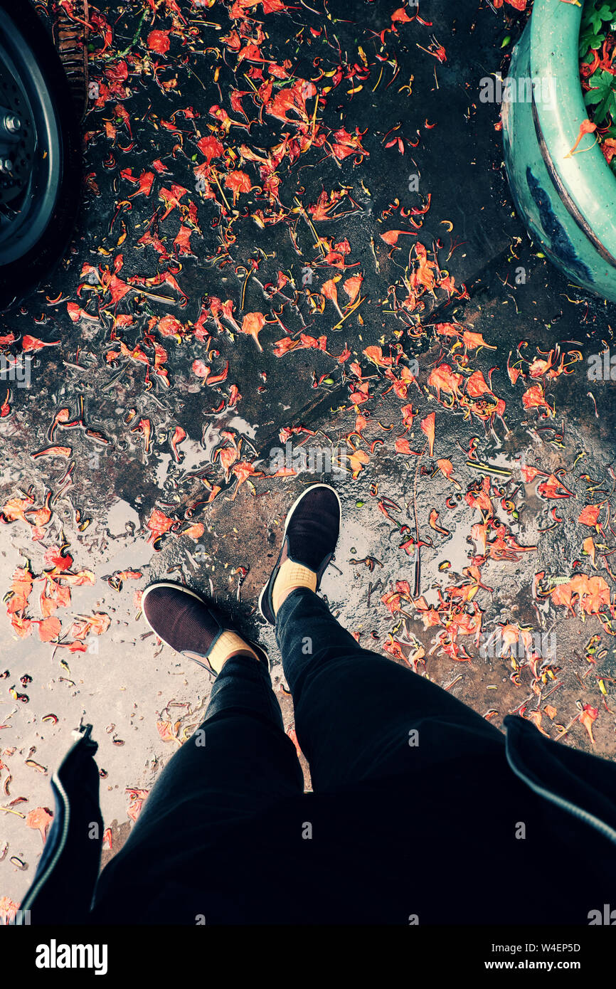 Top view of woman feet in black clothes stand outdoor yard with orange ...