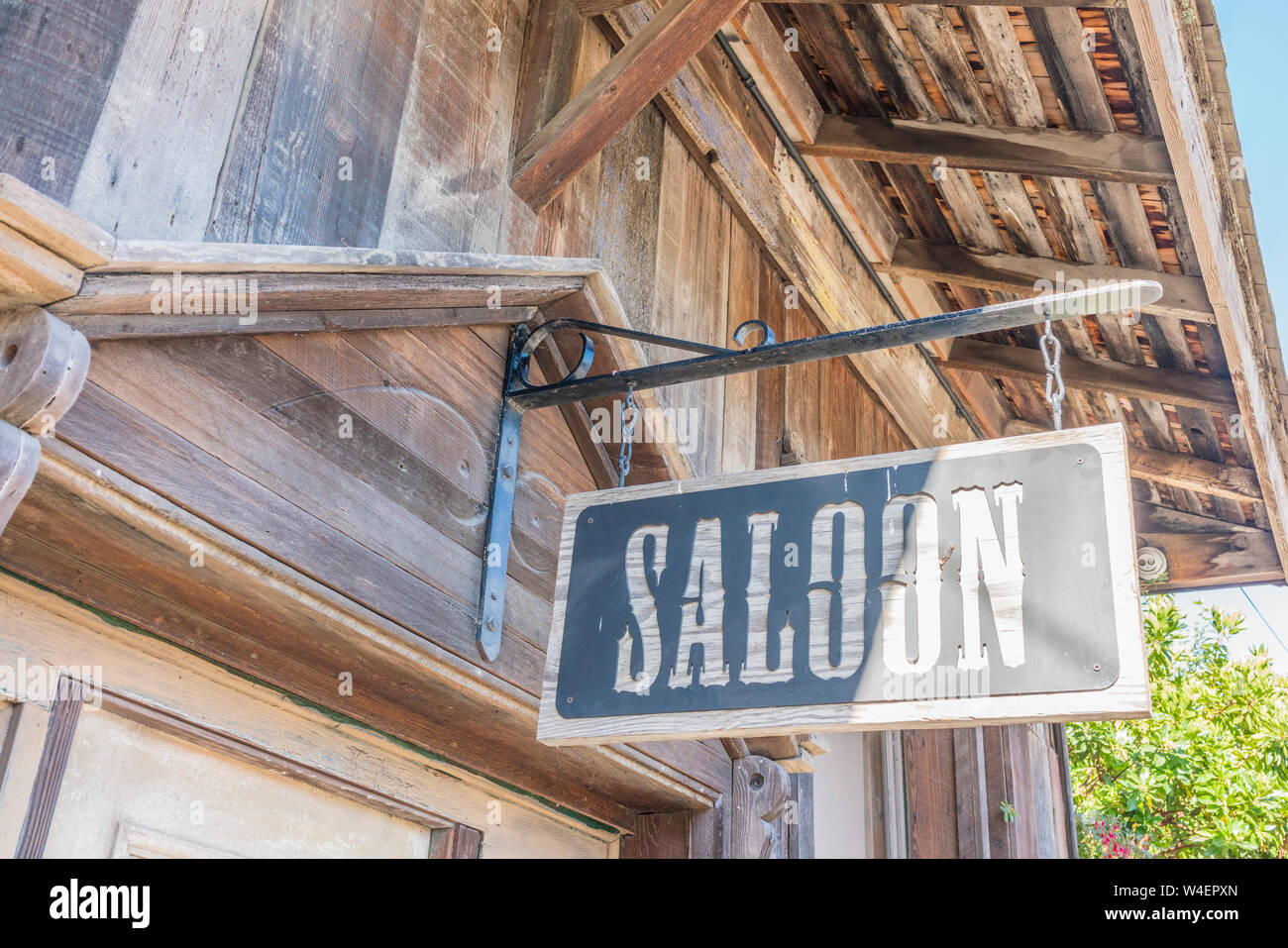 Old west wood and metal handmade sign hangs from an old wooden ...