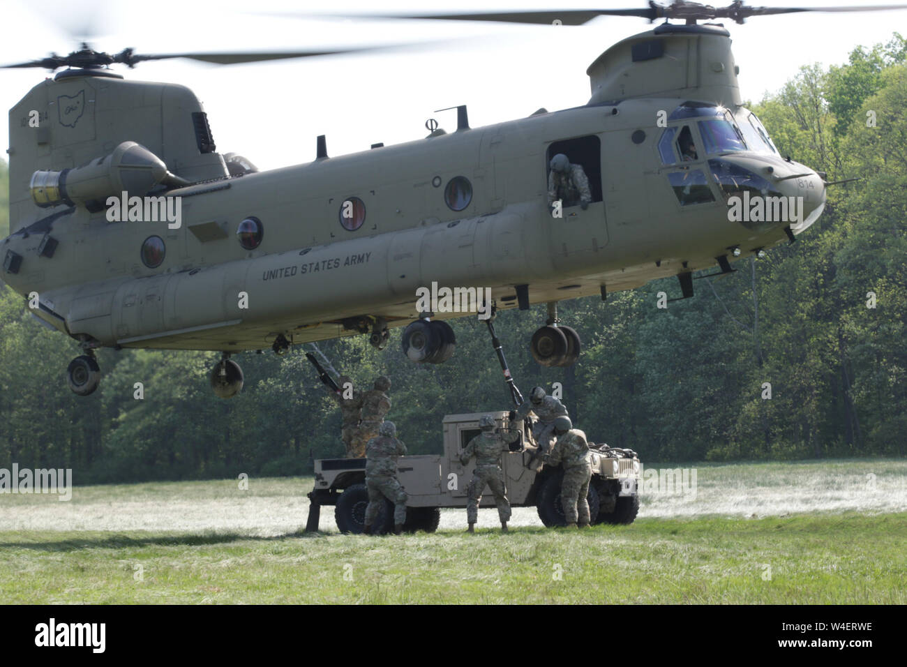 Ohio National Guard Soldiers link up a Humvee to the underside of a CH-47 Chinook helicopter ...