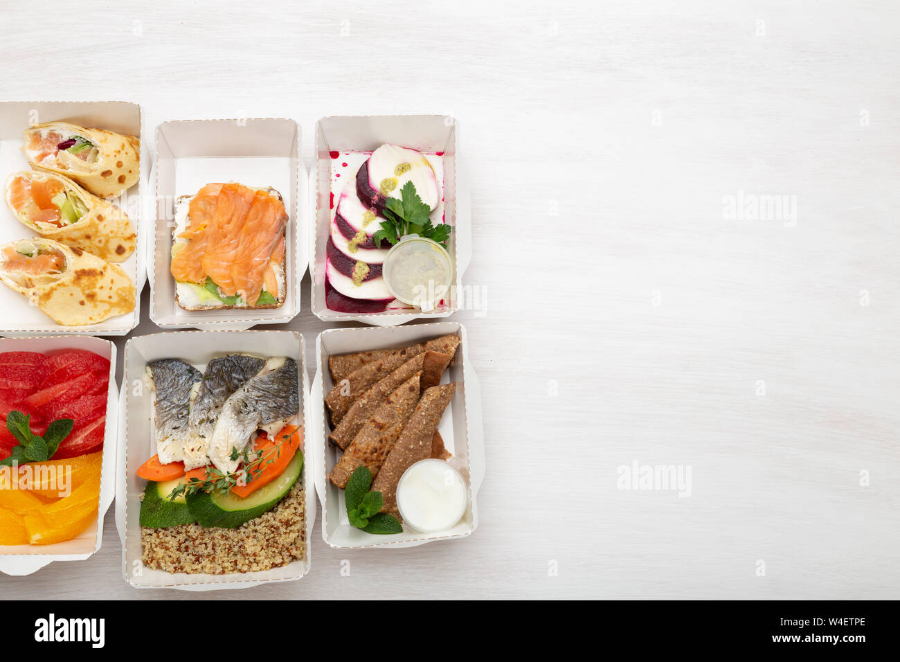 Set of healthy meals for the day in lunch boxes stands on a white table ...