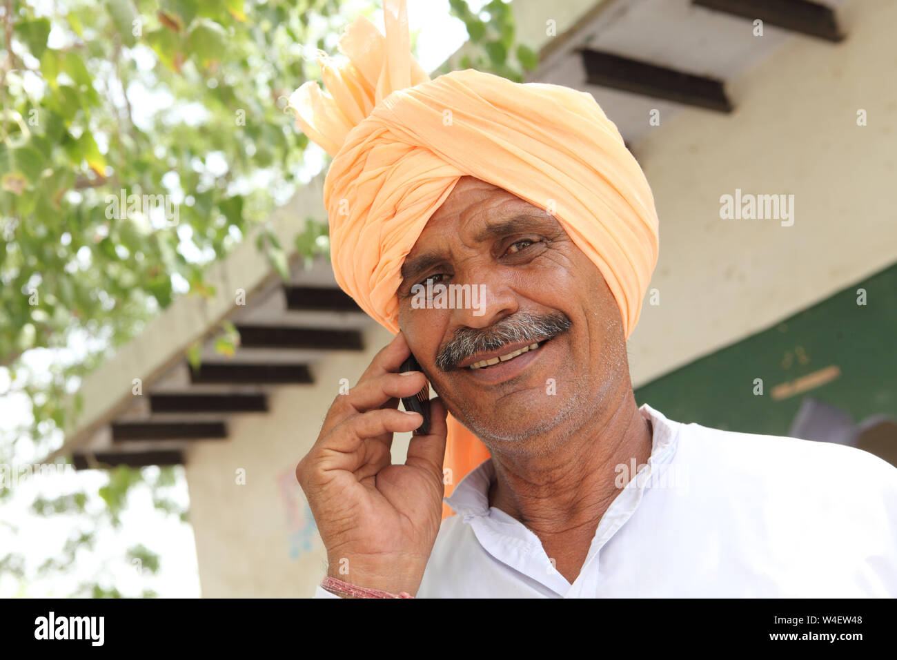 Rural man talking on a mobile phone and smiling Stock Photo - Alamy