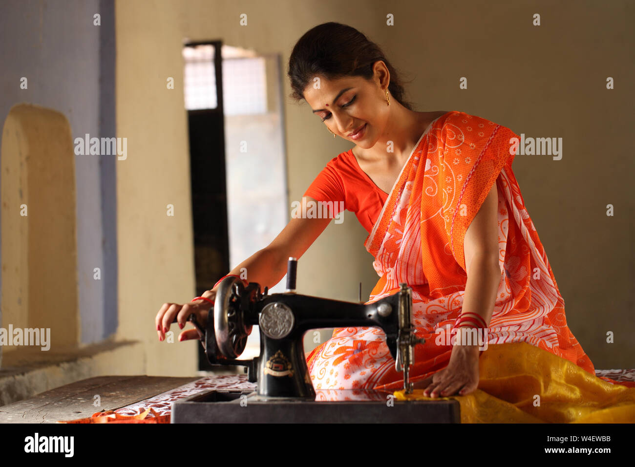 Woman using sewing machine Stock Photo - Alamy