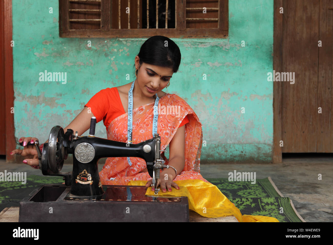 Woman using sewing machine Stock Photo - Alamy