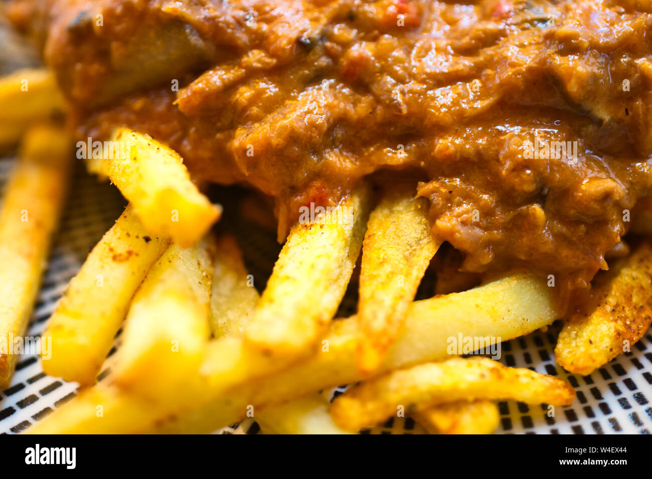 Close-up of crispy fried French fries with warmed up goulash, typical ...