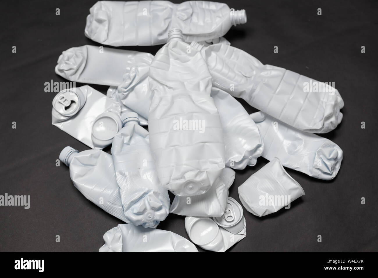 Crumpled plastic bottles lies on a black background. Concept of ...